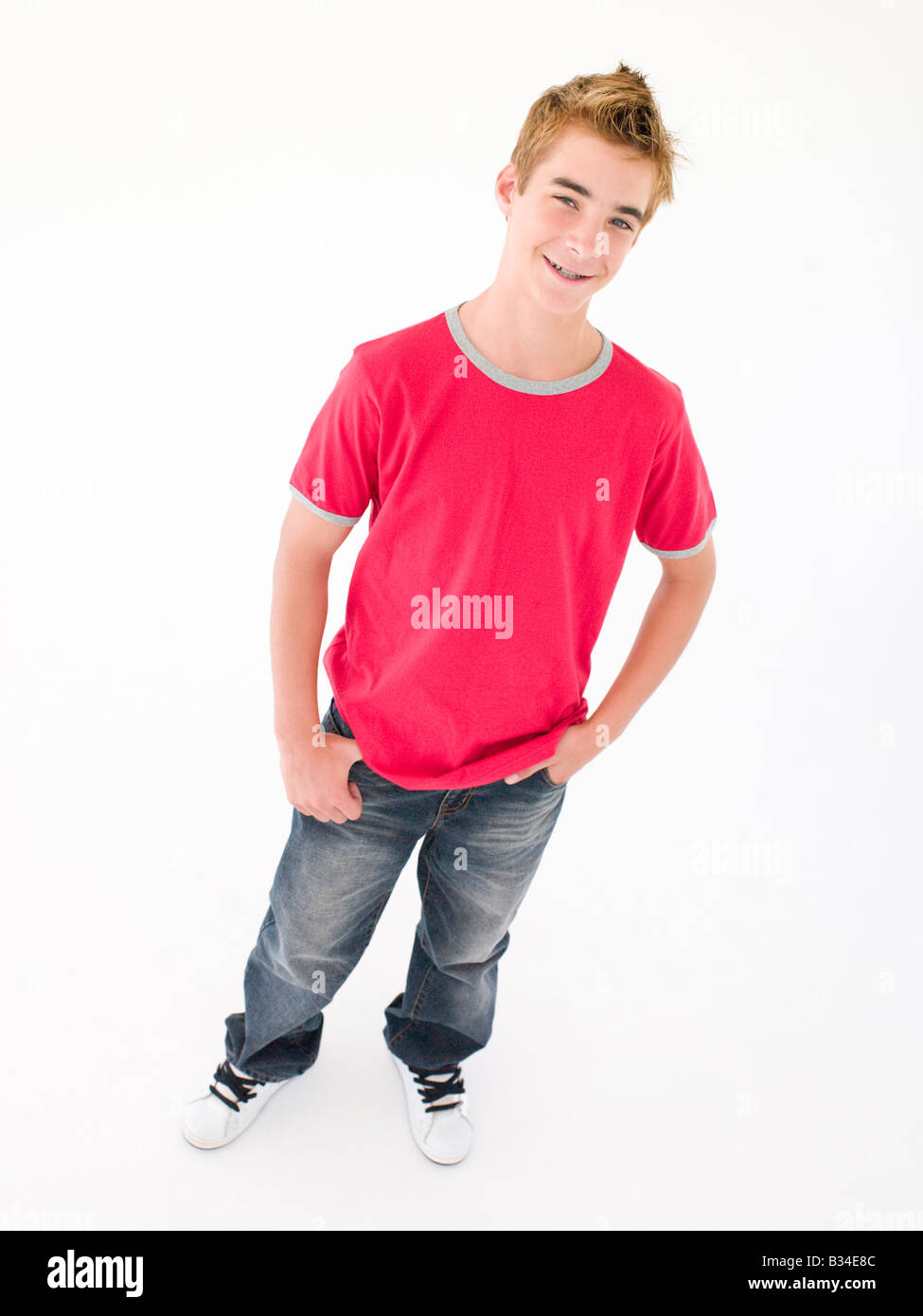 Teenage boy with hands in pockets smiling Stock Photo - Alamy