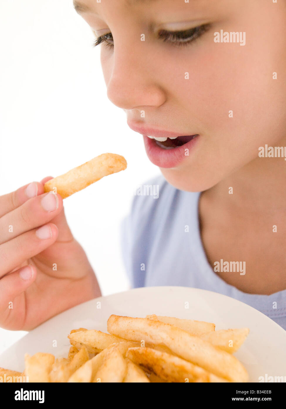 Young girl eating French fries Stock Photo - Alamy