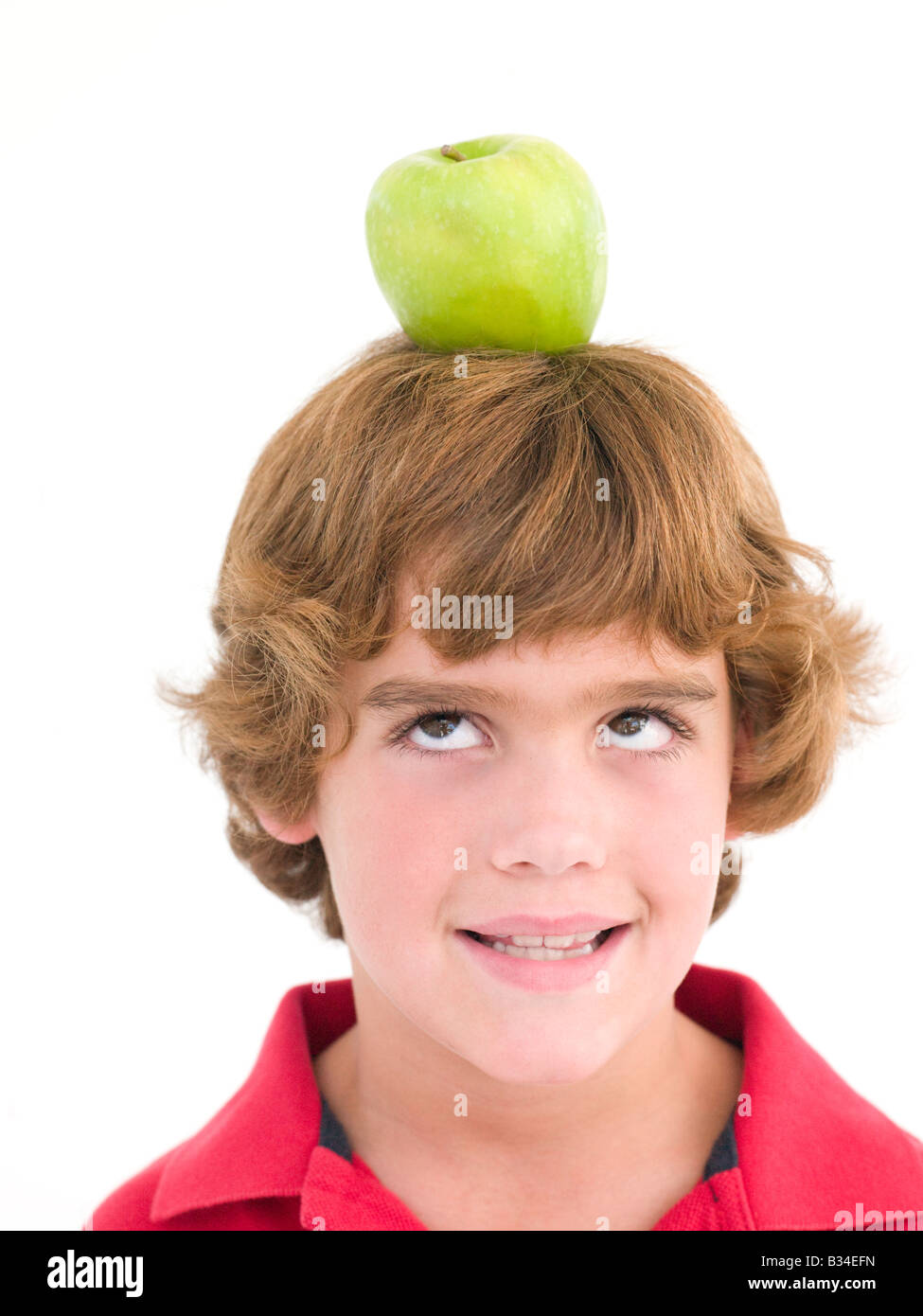 Young boy with apple on his head smiling Stock Photo - Alamy