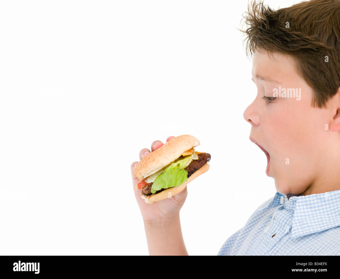 Young boy eating cheeseburger Stock Photo - Alamy