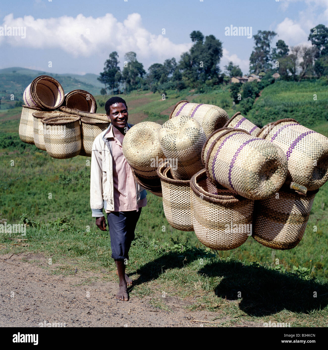Uganda, Southwest Uganda, Muko. A man carries traditional split-bamboo ...