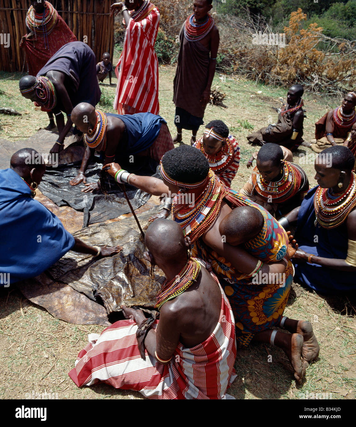 Kenya, Samburu District, Porro. Mothers rub animal fat into their sons ...