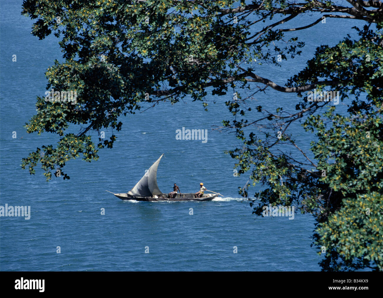 Kenya, Coast Province, Kilifi. A small wooden fishing boat sails up ...