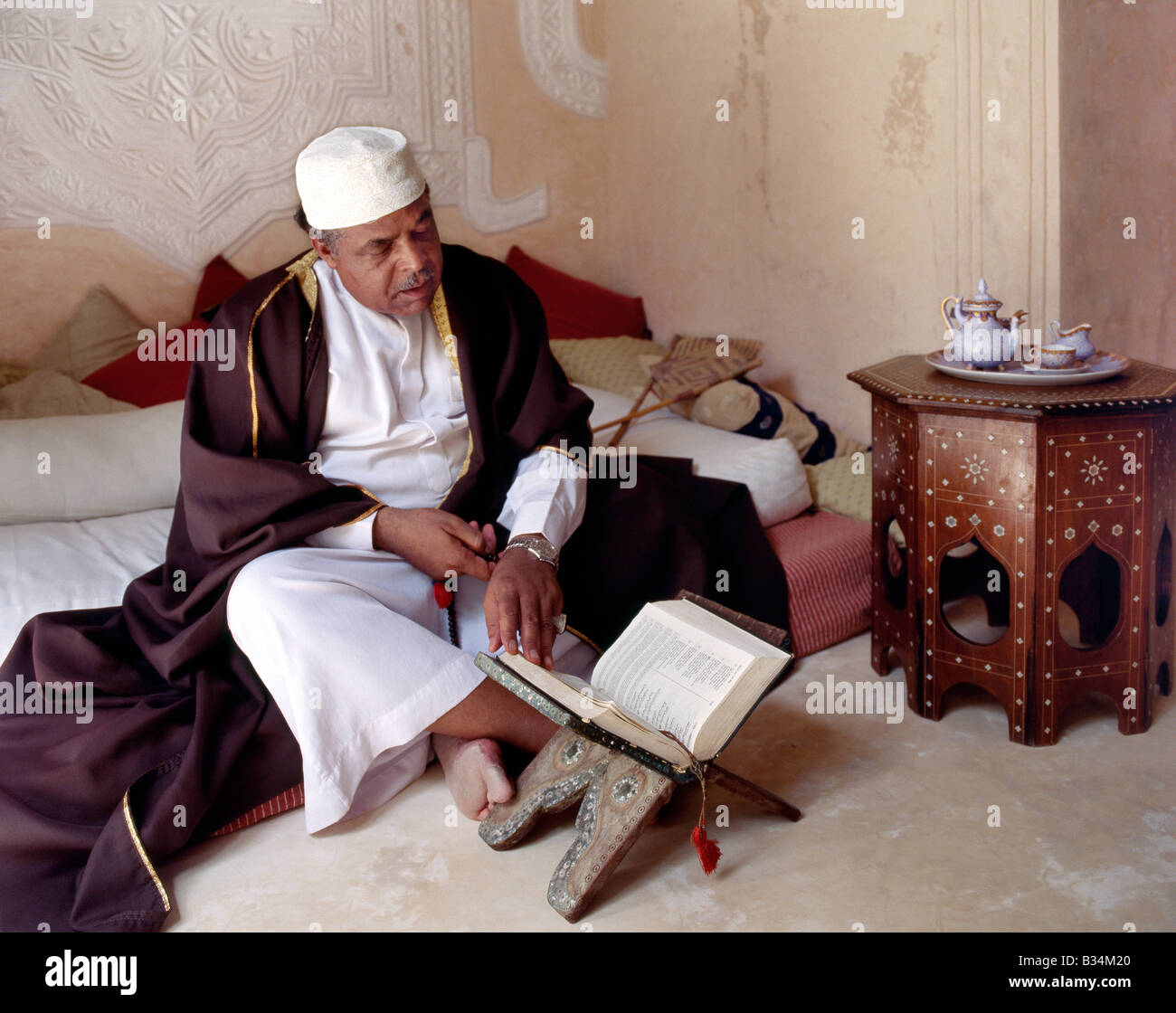 Kenya, Coast Province, Lamu Island. Abdul Malik Bilali recites the Holy ...
