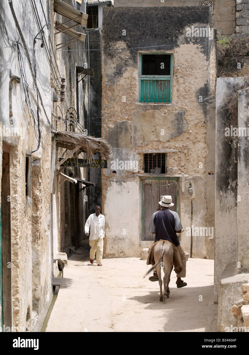 Kenya, Coast Province, Lamu Island. A man rides a donkey through the ...