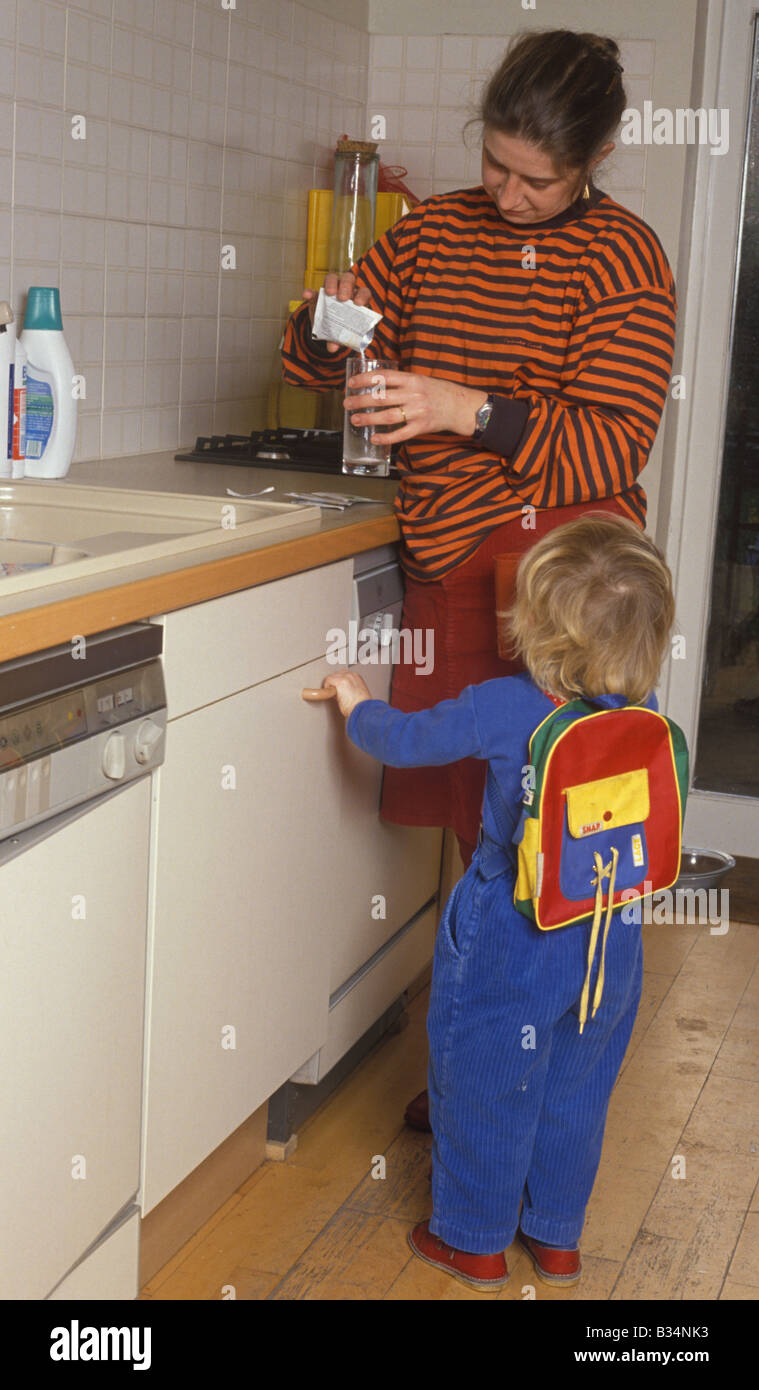 woman giving sachet of powder to young son Stock Photo - Alamy