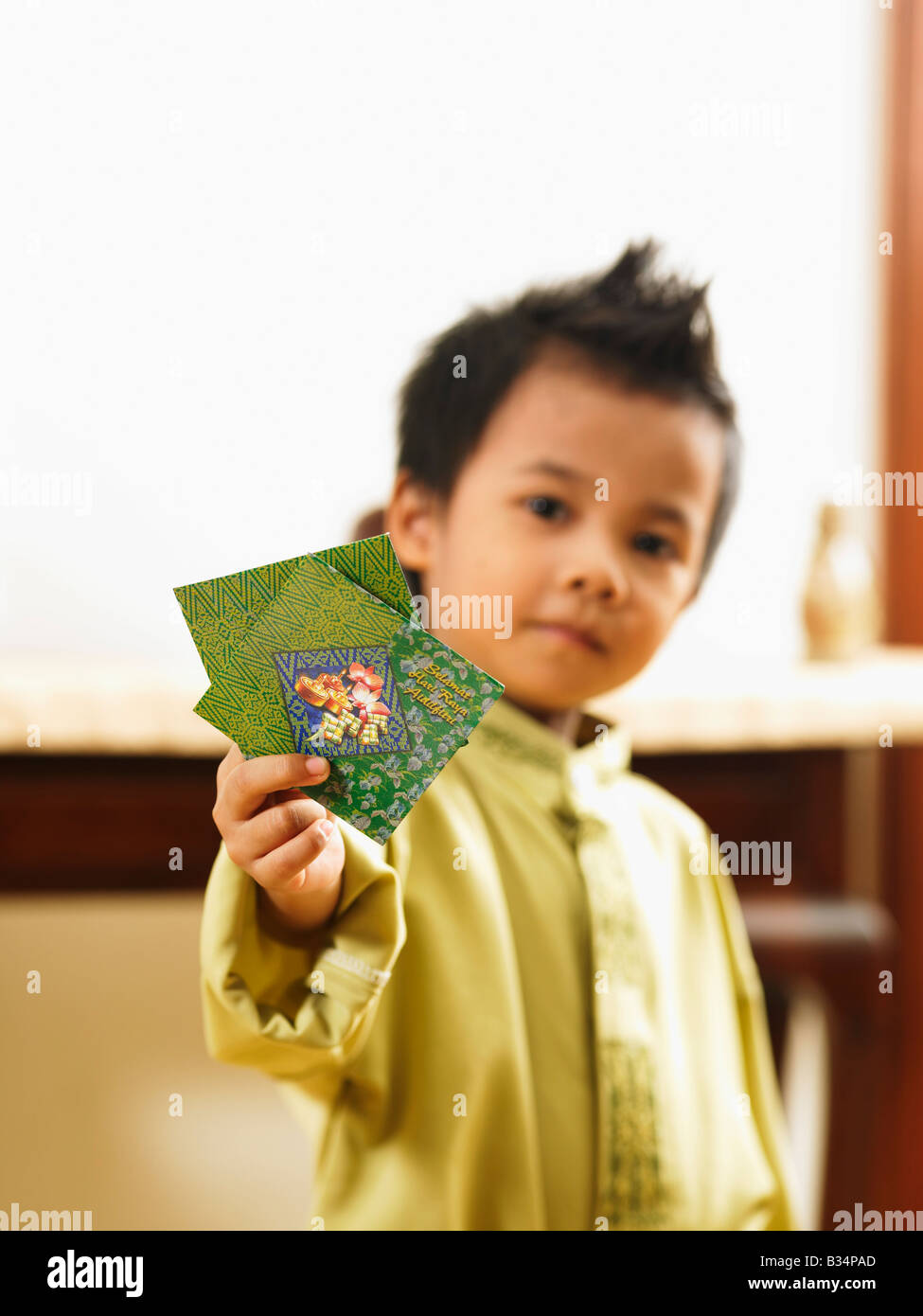 Malay boy showing two green packet Stock Photo - Alamy