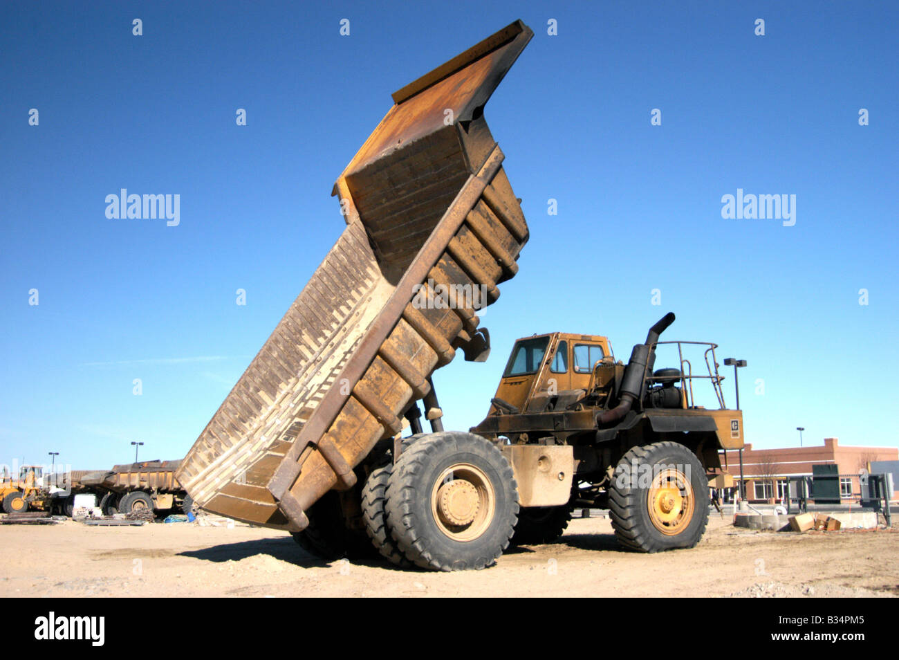 Large yellow dump truck with bed up Stock Photo - Alamy