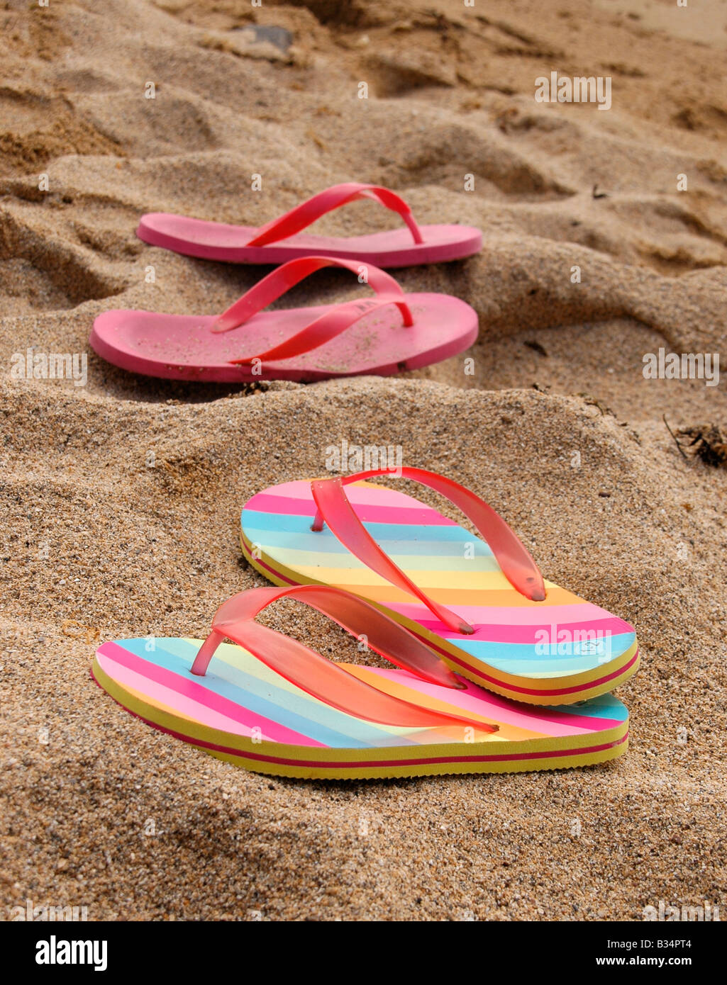 A pair of flip flops on sand Stock Photo - Alamy