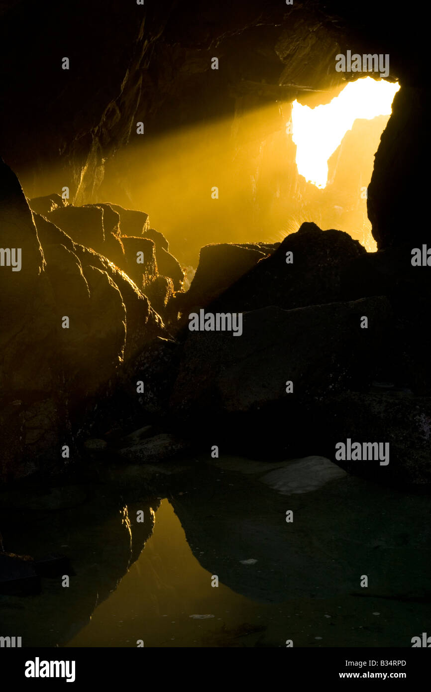 A shaft of warm sunset light pours through an arch at Big Sur s ...