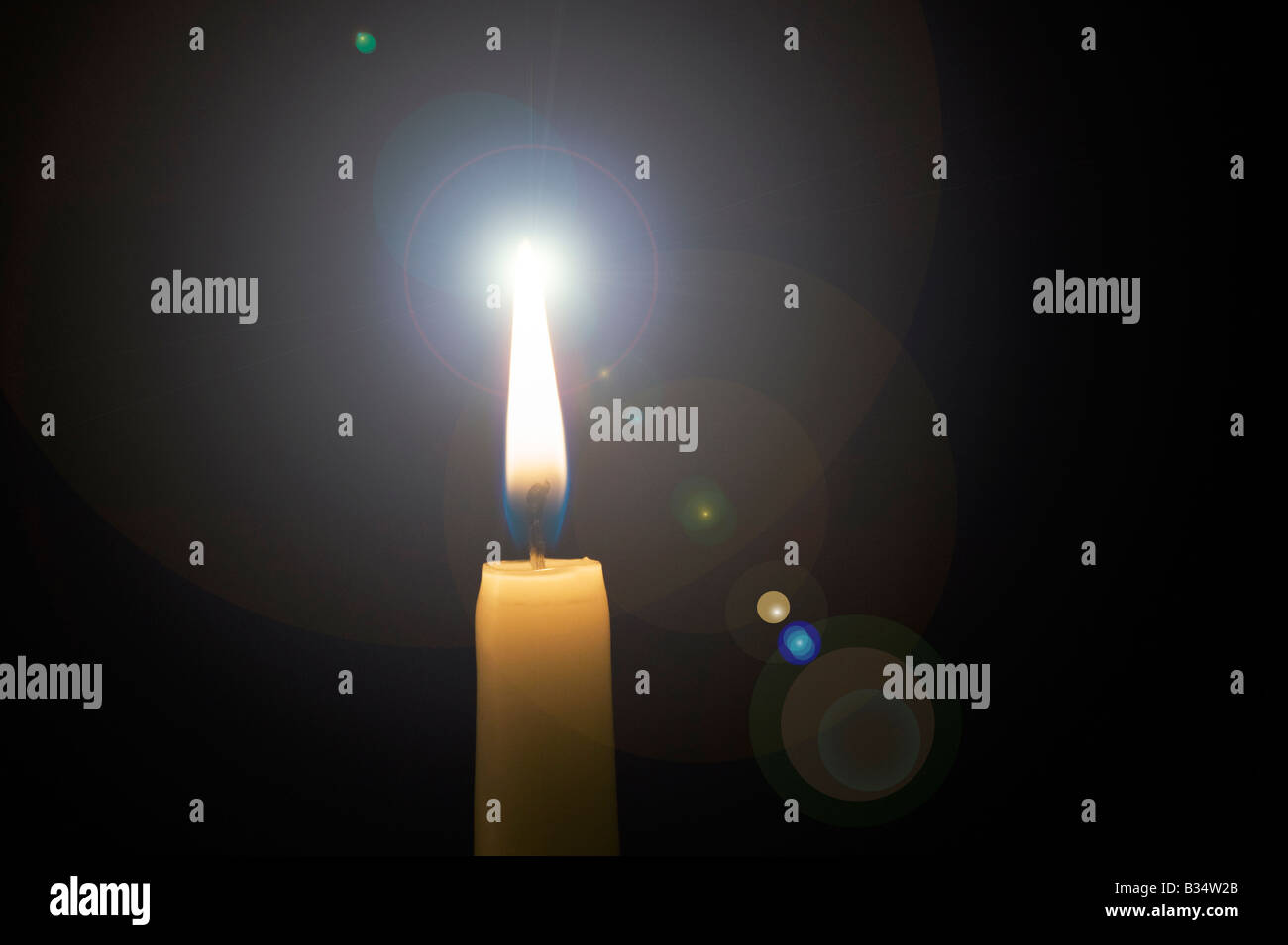 Lighted candle and lens flare against black Stock Photo - Alamy