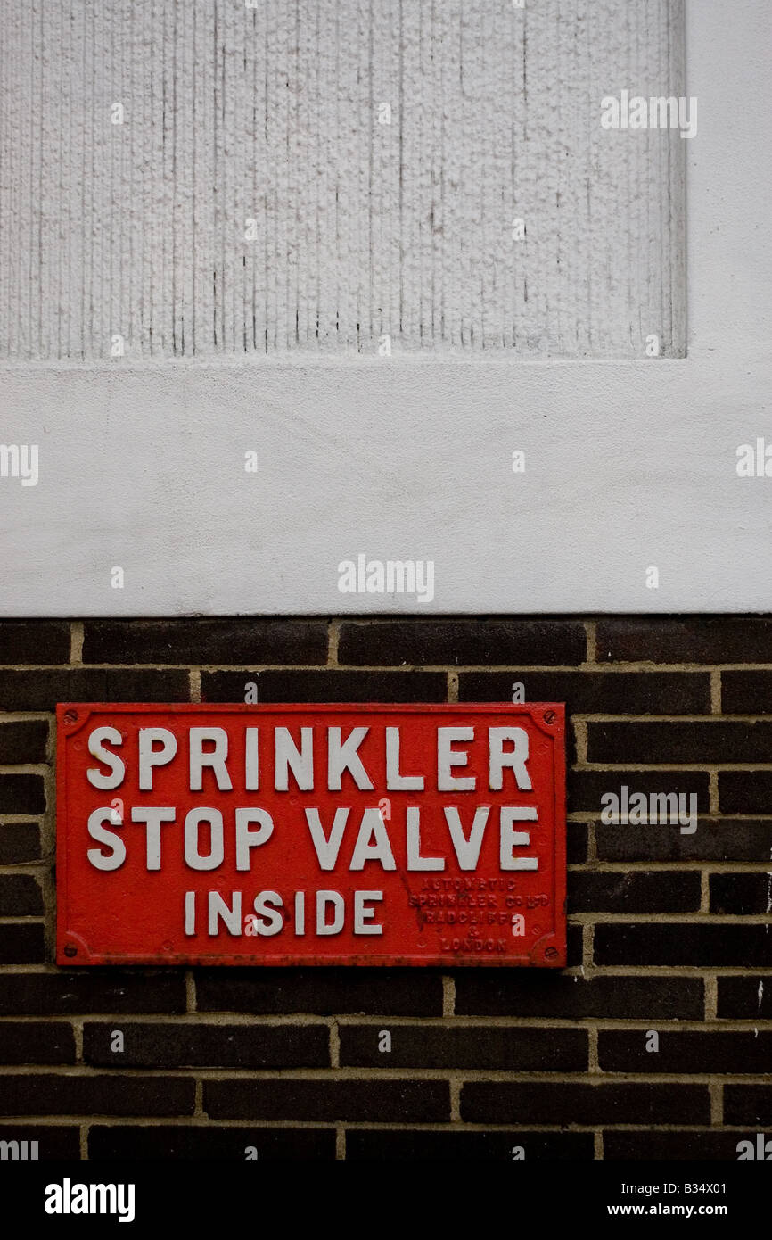 Sprinkler stop valve sign on the exterior brick wall of a building ...