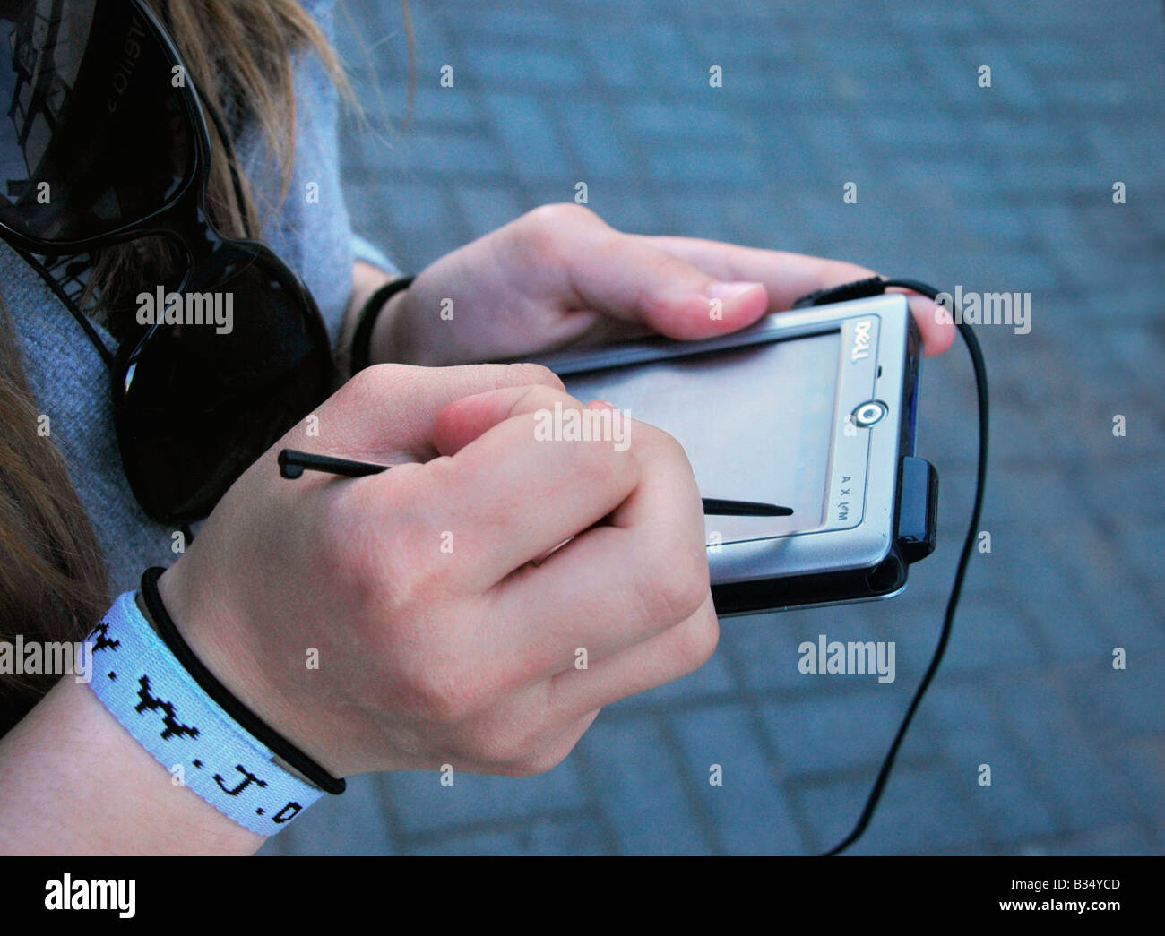 a close up of a young woman, teenager, using her PDA - personal digital ...