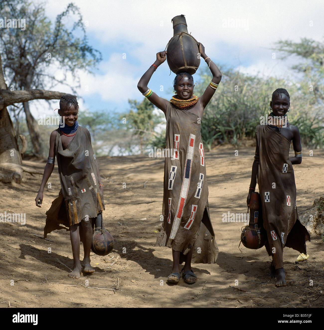 Kenya, Turkana, Nachola. Turkana girls return home from a Waterhole ...