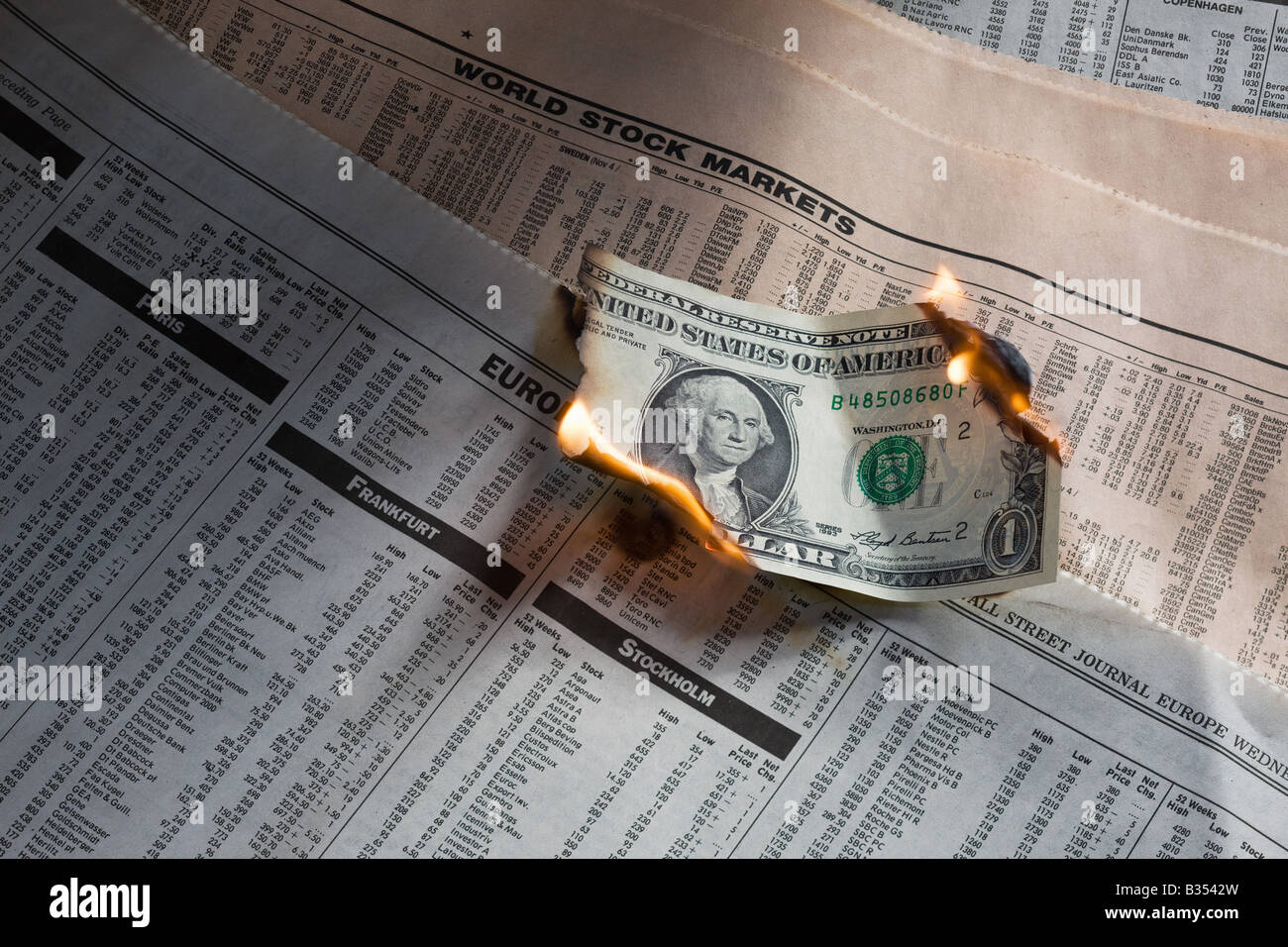 ONE US DOLLAR BILL BURNING ON FINANCIAL PAPERS Stock Photo - Alamy