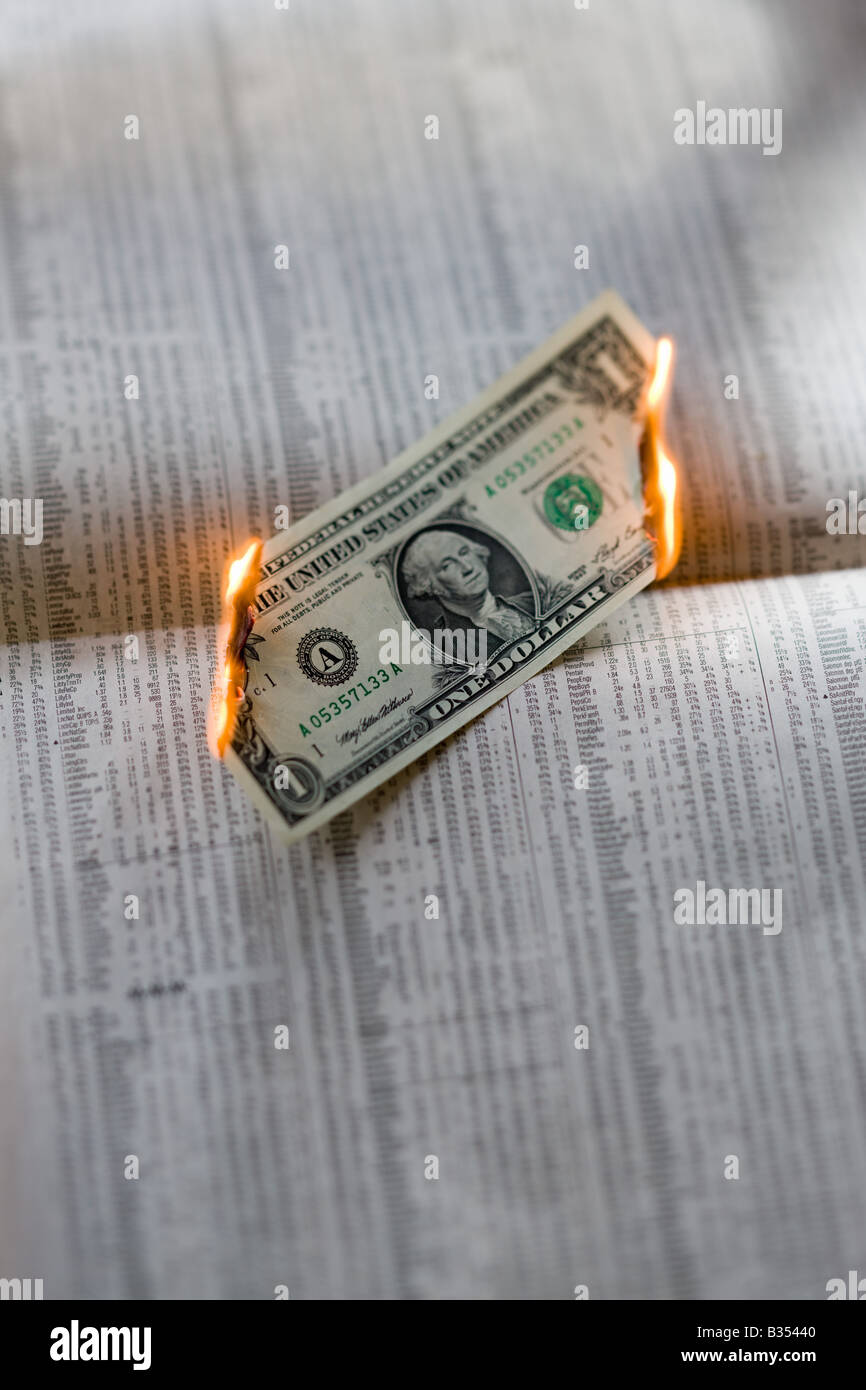 ONE US DOLLAR BILL BURNING ON FINANCIAL PAPER Stock Photo - Alamy