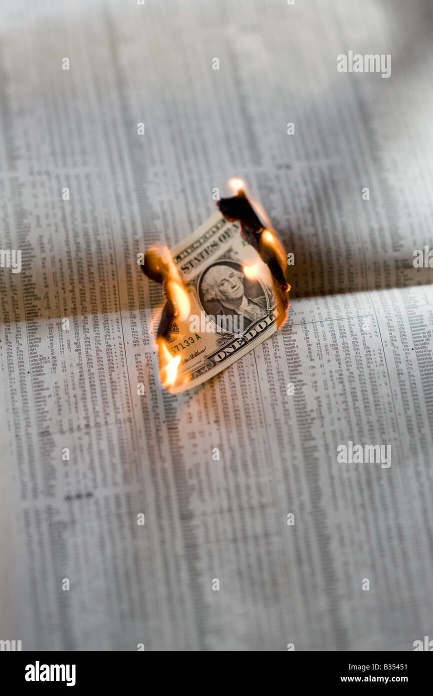 ONE US DOLLAR BILL BURNING ON FINANCIAL PAPER Stock Photo - Alamy