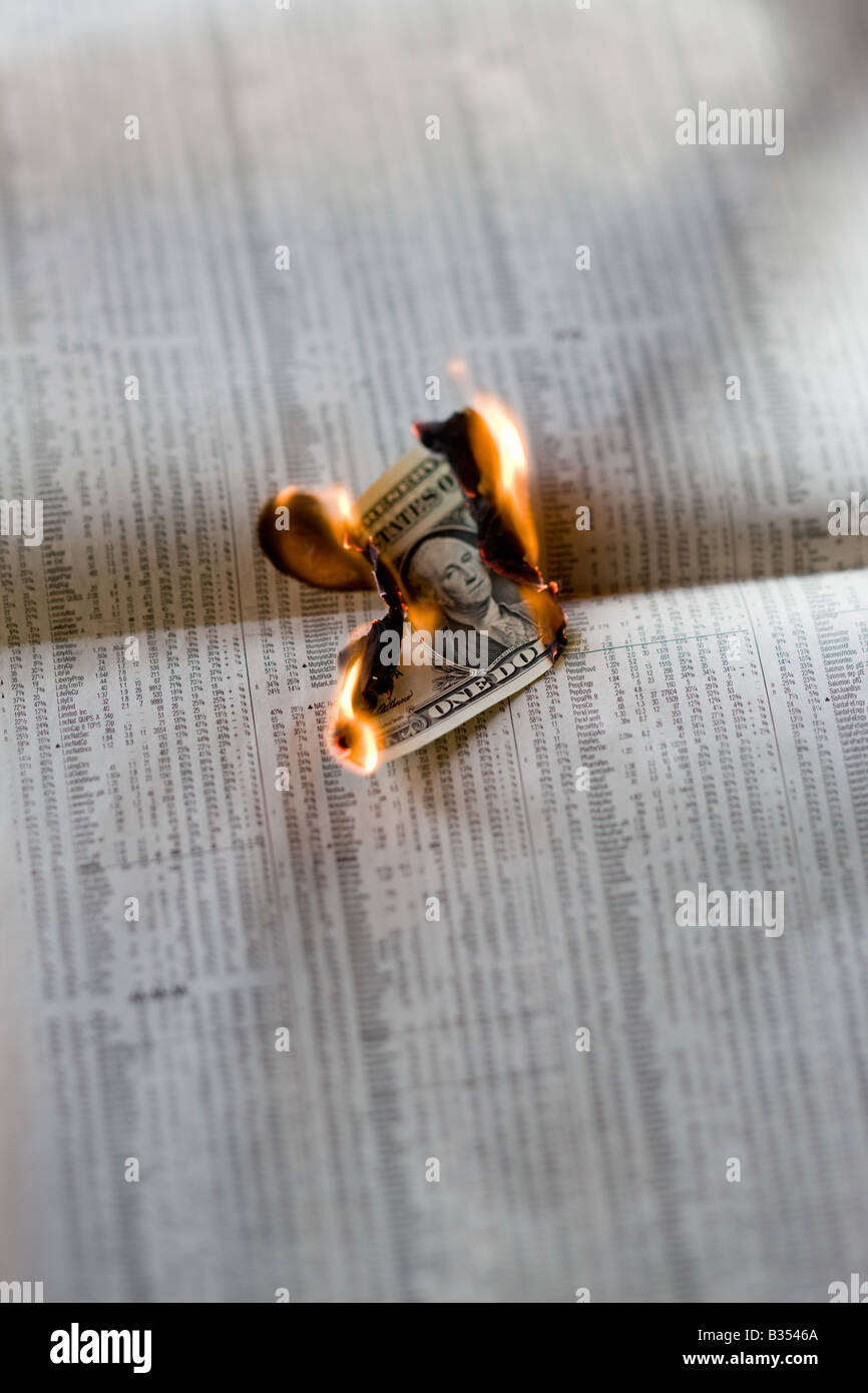 ONE US DOLLAR BILL BURNING ON FINANCIAL PAPER Stock Photo - Alamy