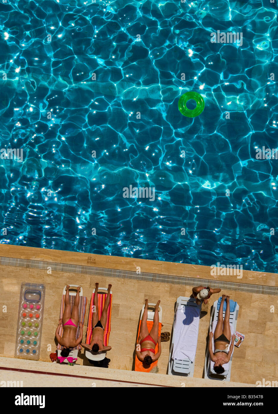 Tourists sunbathing by a pool Turkey Stock Photo - Alamy