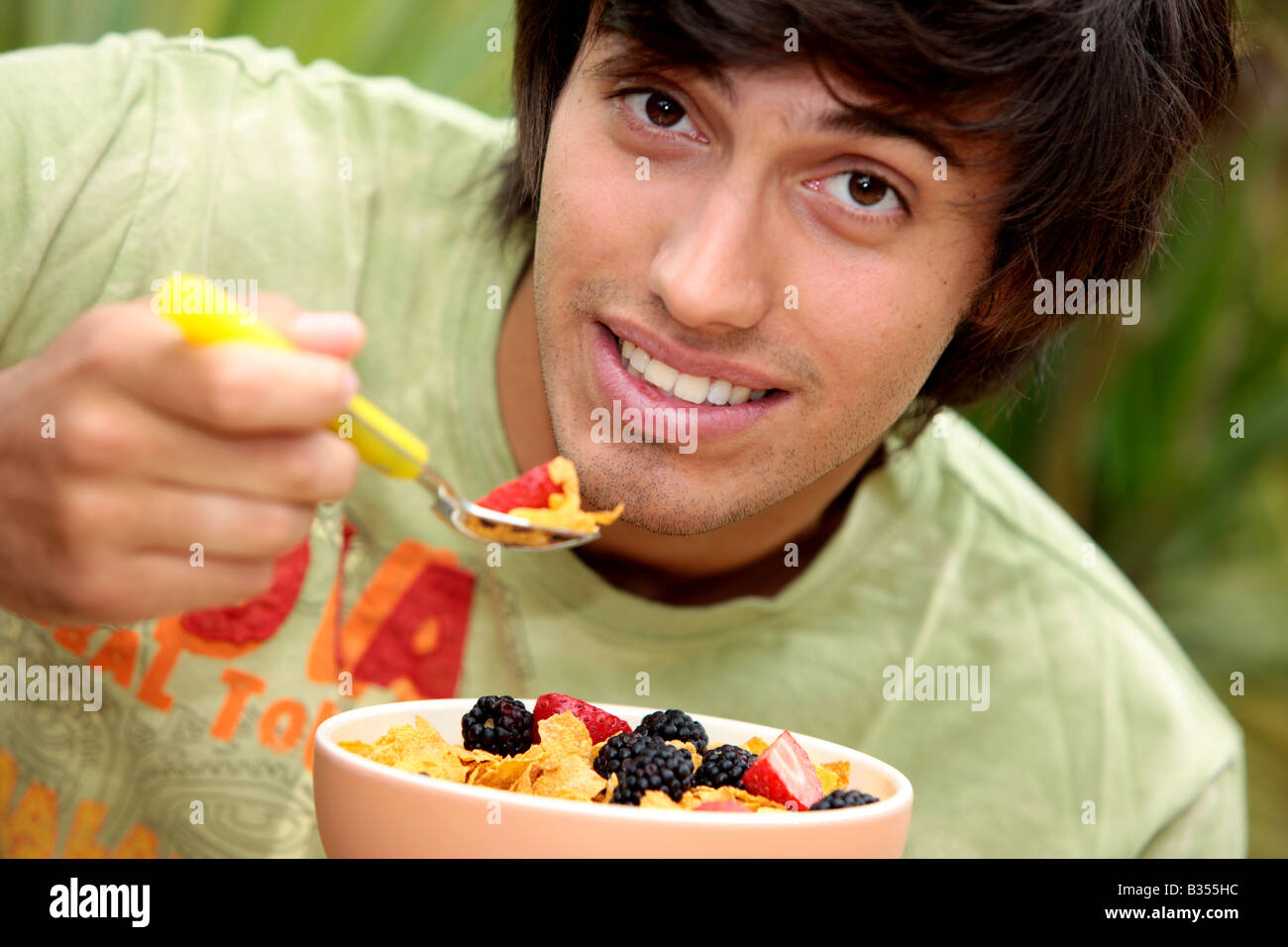 Young Man Eating Cornflakes with Berries Model Released Stock Photo - Alamy