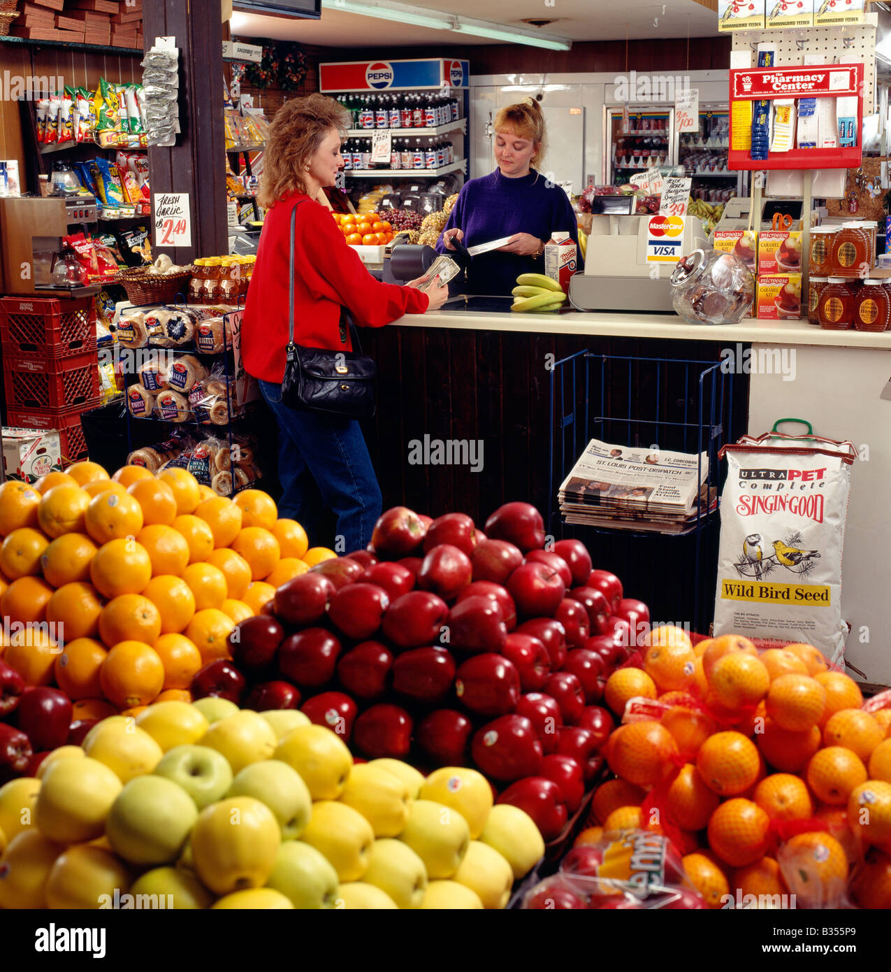 Woman paying at a cash register in a convenience store Stock Photo - Alamy