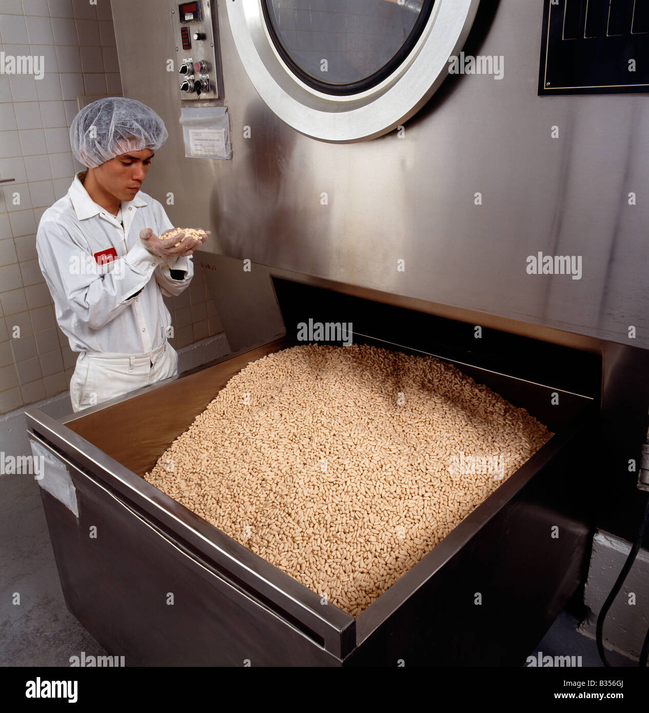 Quality control worker examining tablets in a pharmaceutical ...