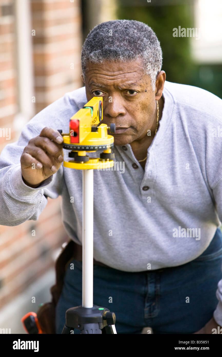 African American man using a laser level Stock Photo - Alamy