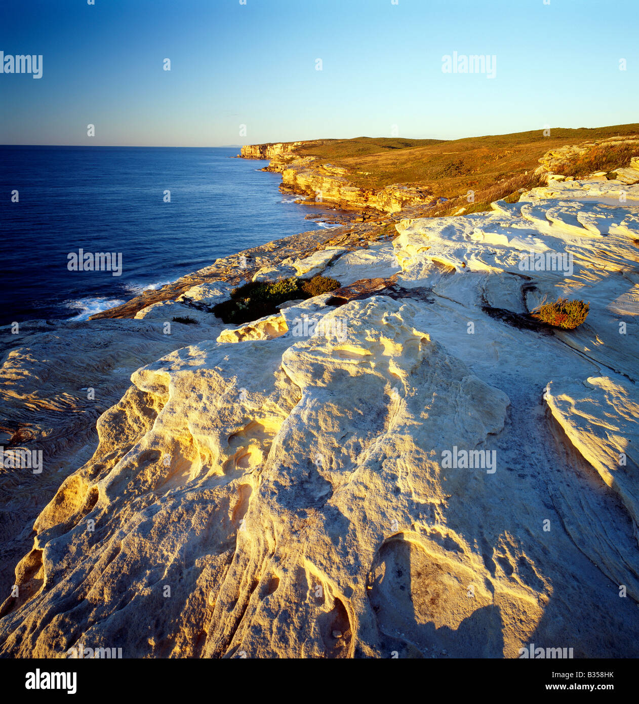 Sunrise view of sandstone cliffs along Pacific Ocean at Royal National ...