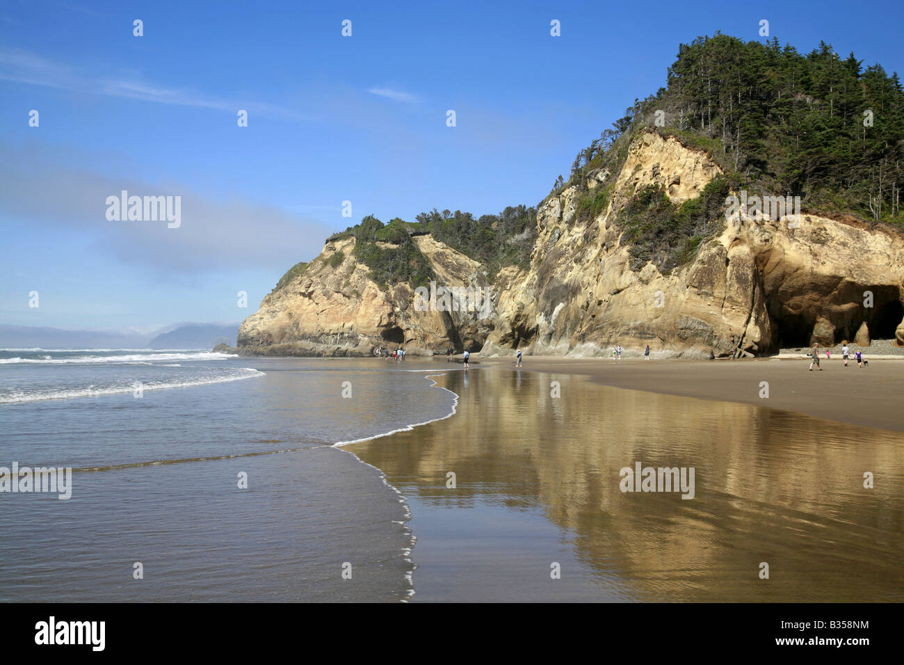 Visitors walk along the beautiful beach at Hug Point State Park near ...