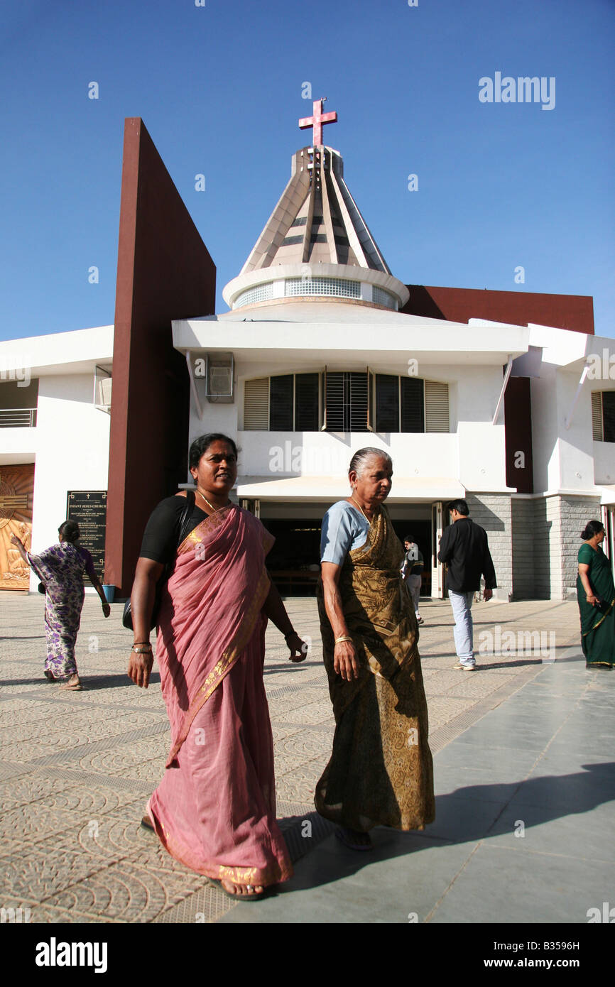 Two women walk past the modern style Church of the Infant Jesus in ...