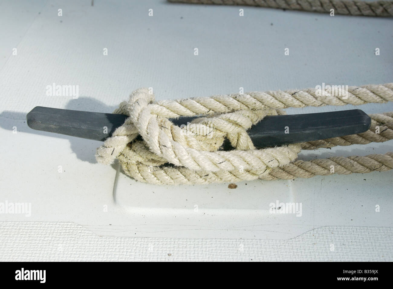 Rope tied fast around boat cleat Stock Photo - Alamy