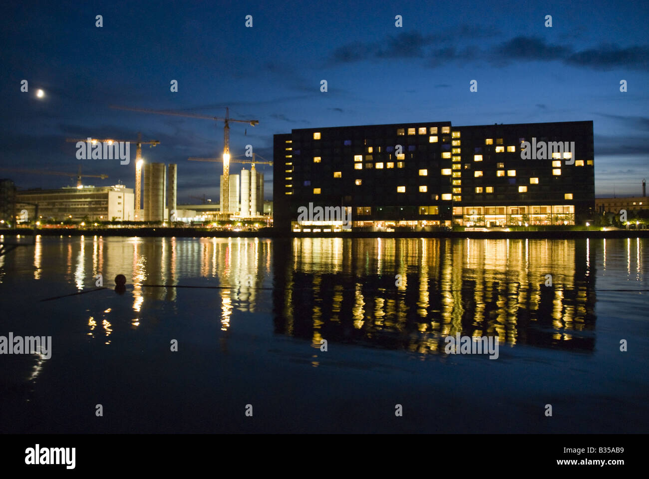 The moon rises over the midnight sky in Copenhagen, Denmark Stock Photo ...