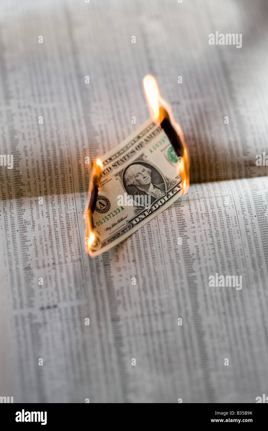 ONE US DOLLAR BILL BURNING ON FINANCIAL PAPER Stock Photo - Alamy