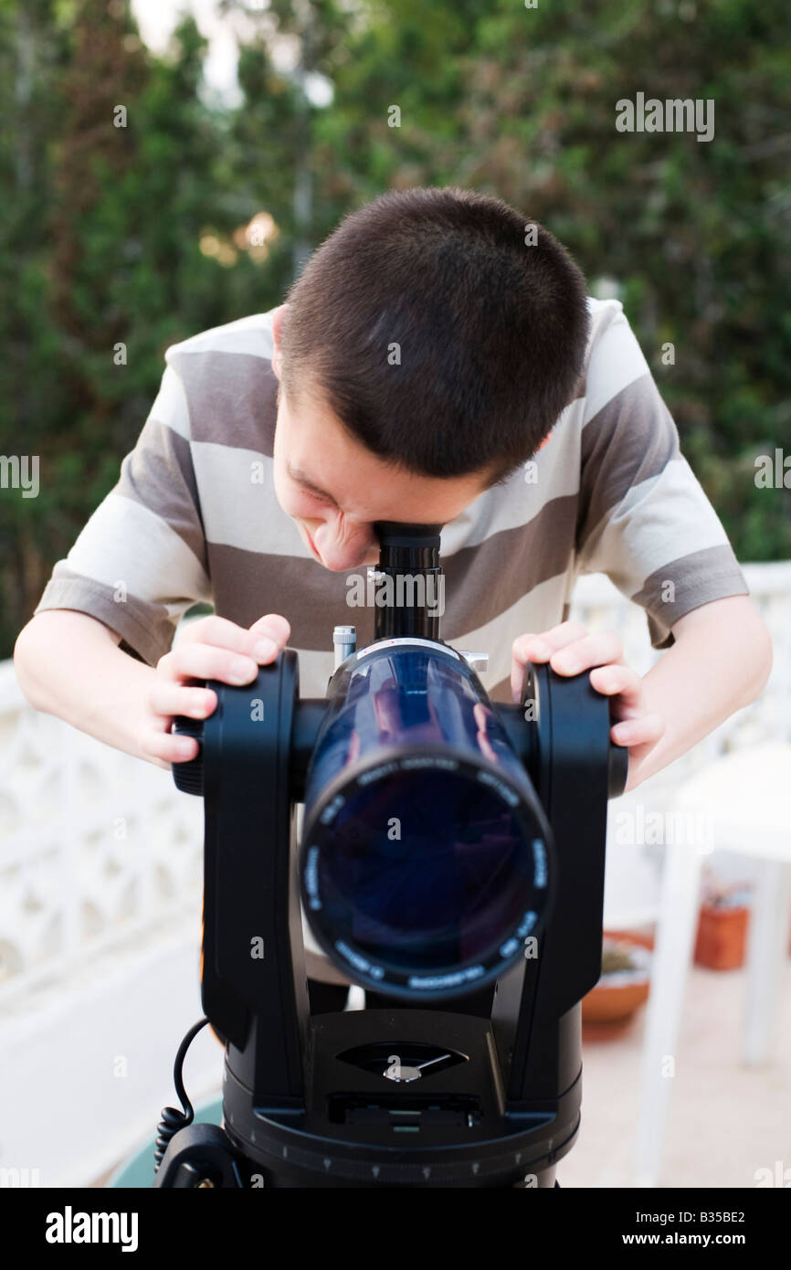 Young boy using a telescope Stock Photo - Alamy