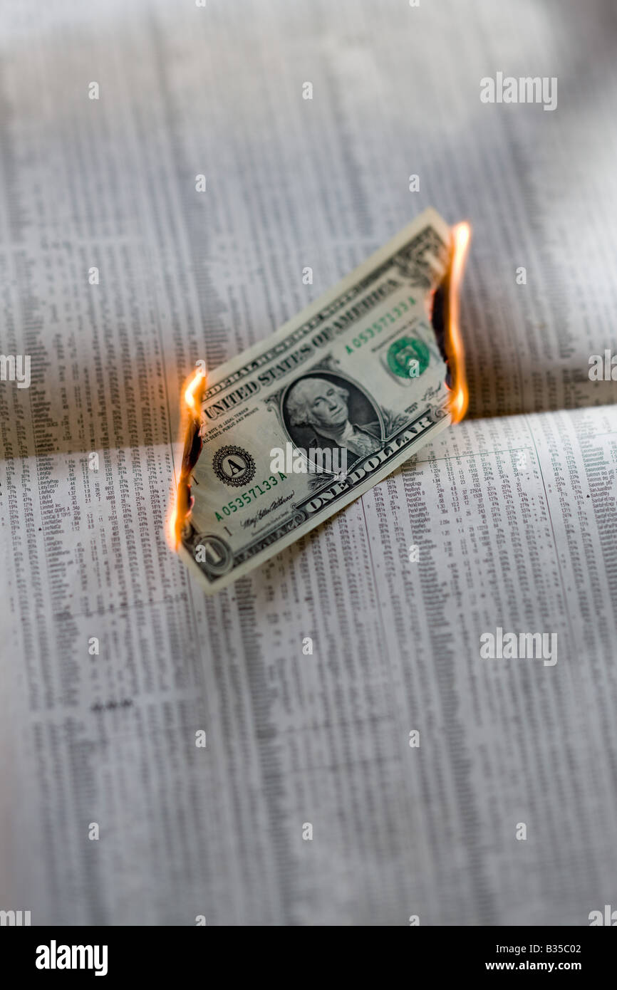 ONE US DOLLAR BILL BURNING ON FINANCIAL PAPER Stock Photo - Alamy