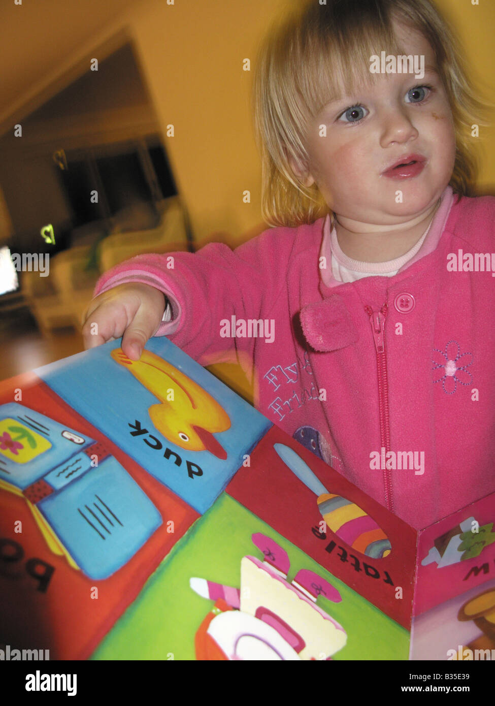 Toddler girl with her first book Stock Photo - Alamy
