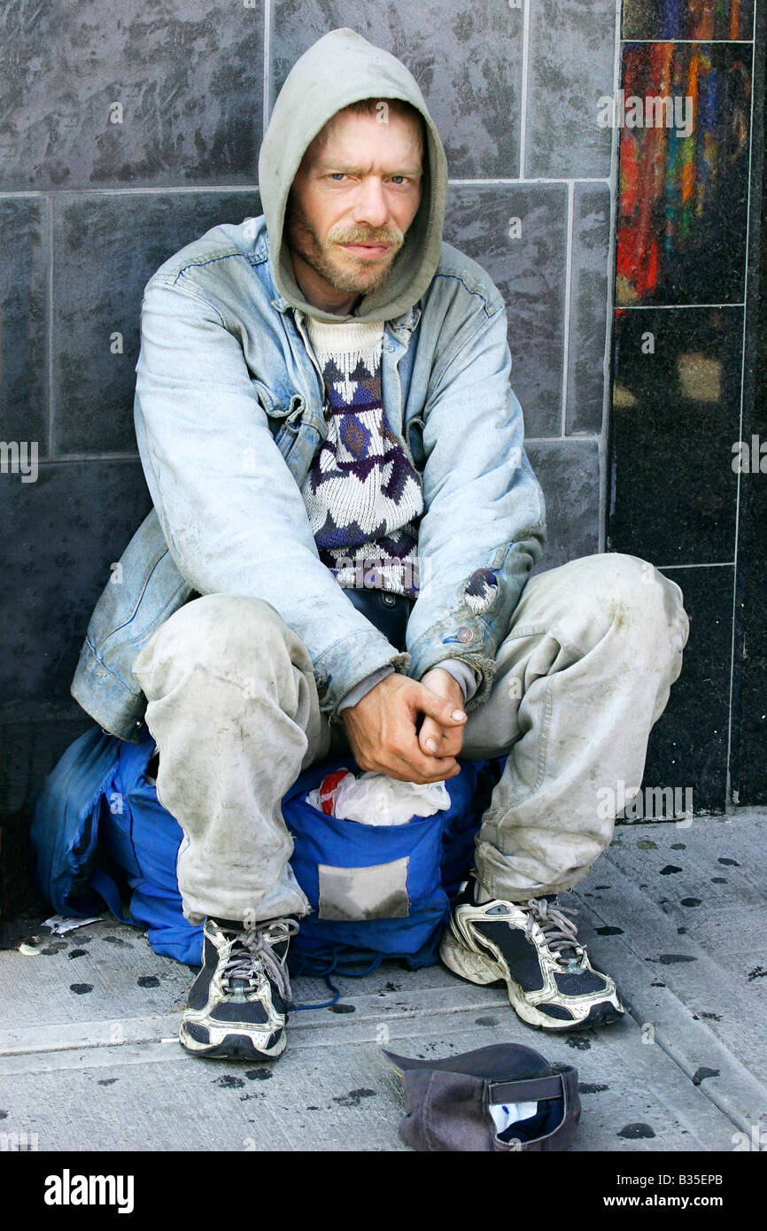 An homeless person is sitting on his backpack Stock Photo - Alamy
