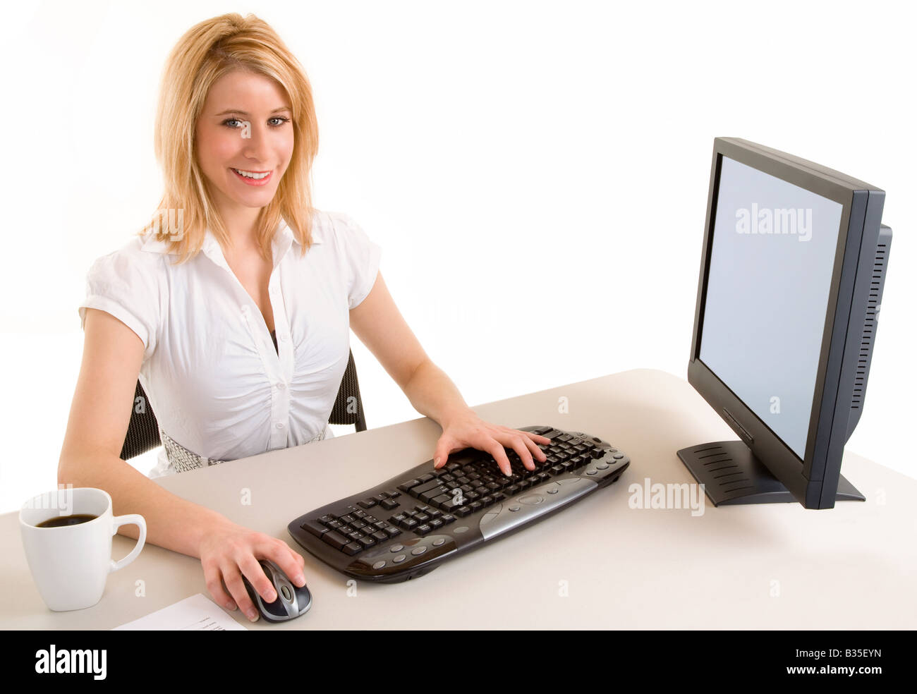 A beautiful blonde businesswoman sitting at her desk and working on her ...