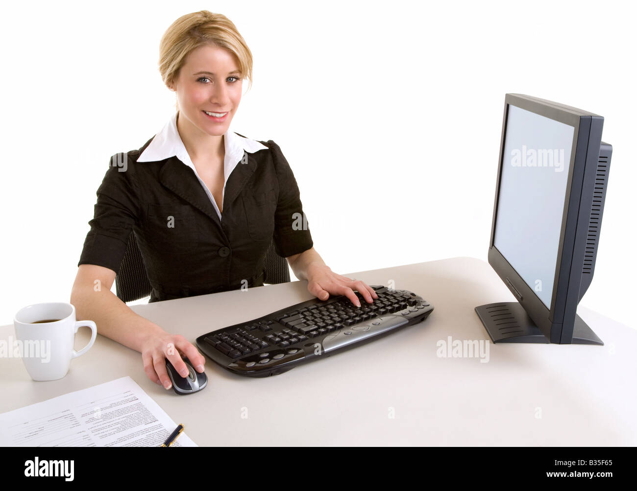 A beautiful blonde businesswoman sitting at her desk and working on her ...