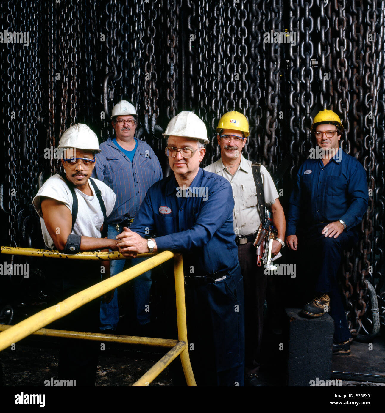 Industrial workers pose for a group photo in a metal fabrication plant ...