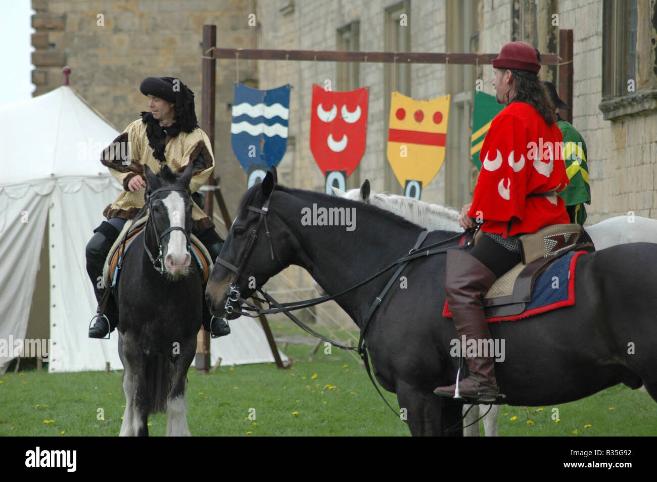 3 squires in medieval dress on horseback Stock Photo - Alamy