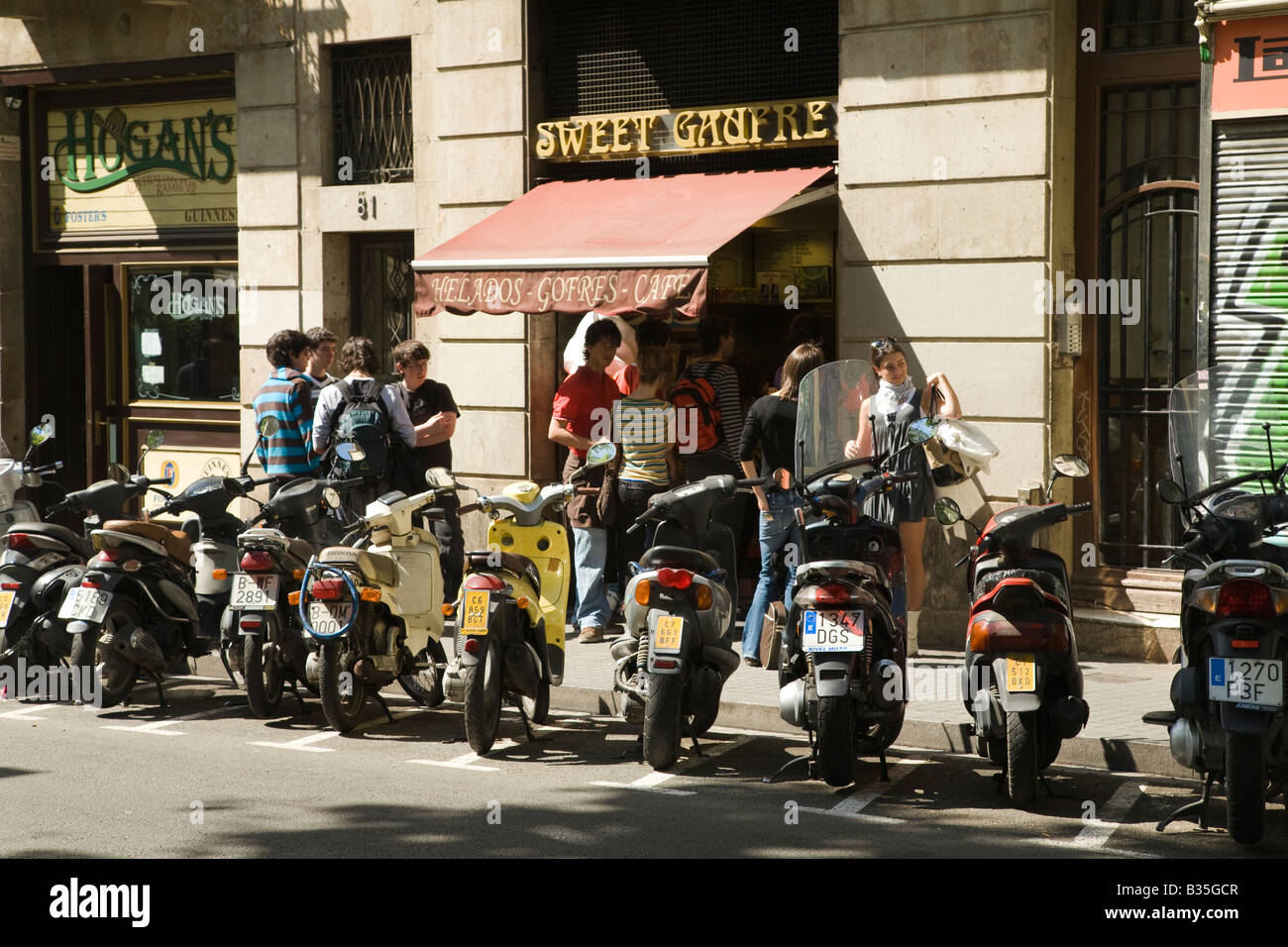 SPAIN Barcelona Motorcycles and scooters parked along street young ...