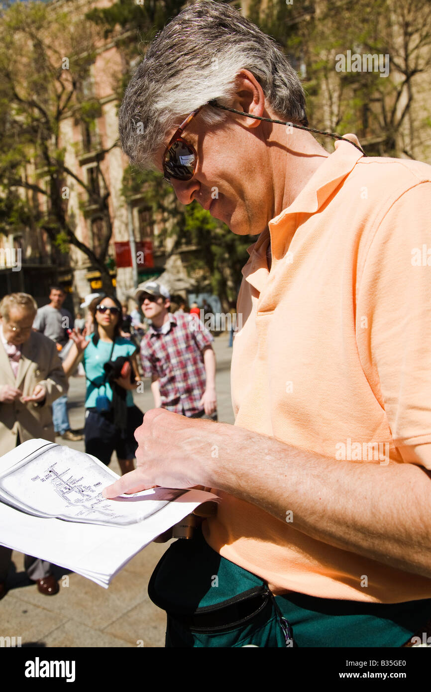 SPAIN Barcelona Male tourist point to place on map in cathedral plaza ...
