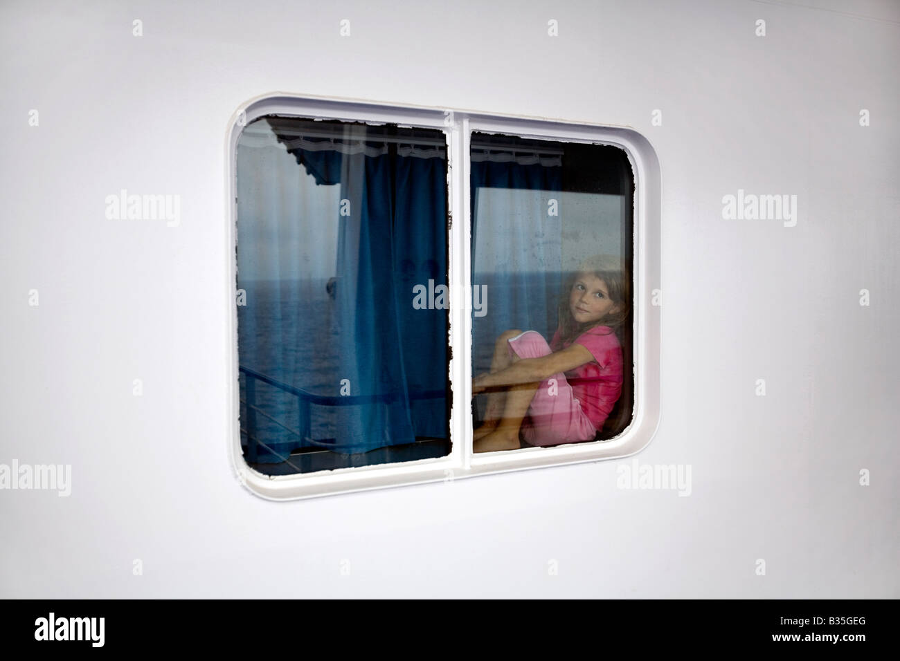 Little girl sitting inside a ferry boat window Stock Photo - Alamy