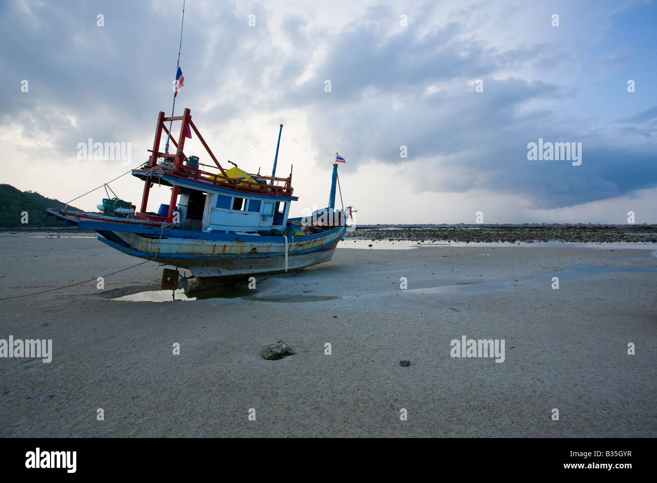 Fishing boat between tides in village in Koh Penang, Thailand Stock ...