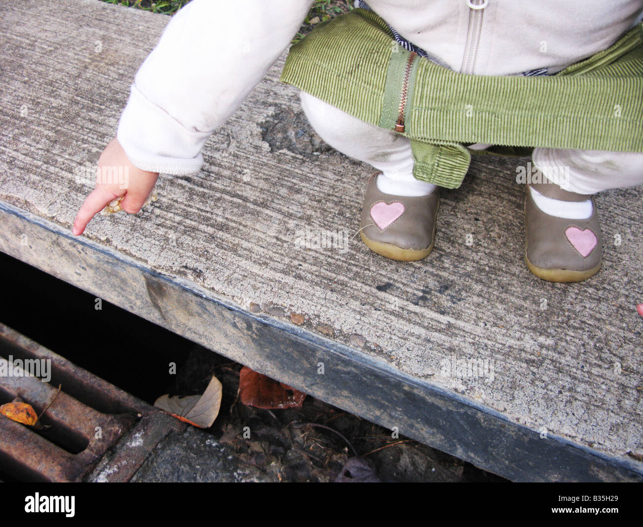 Close up of child pointing at a gutter Stock Photo - Alamy