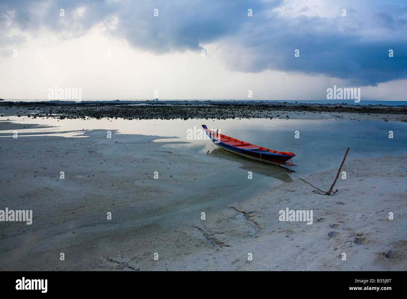 Traditional canoe between tides in village in Koh Penang, Thailand ...
