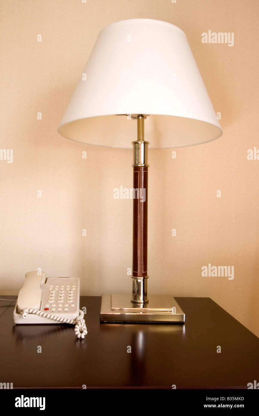 A lamp and a telephone rest on a desk Stock Photo - Alamy