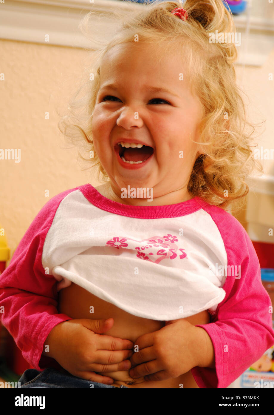 Close-up of a girl touching her belly button and laughing Stock Photo ...
