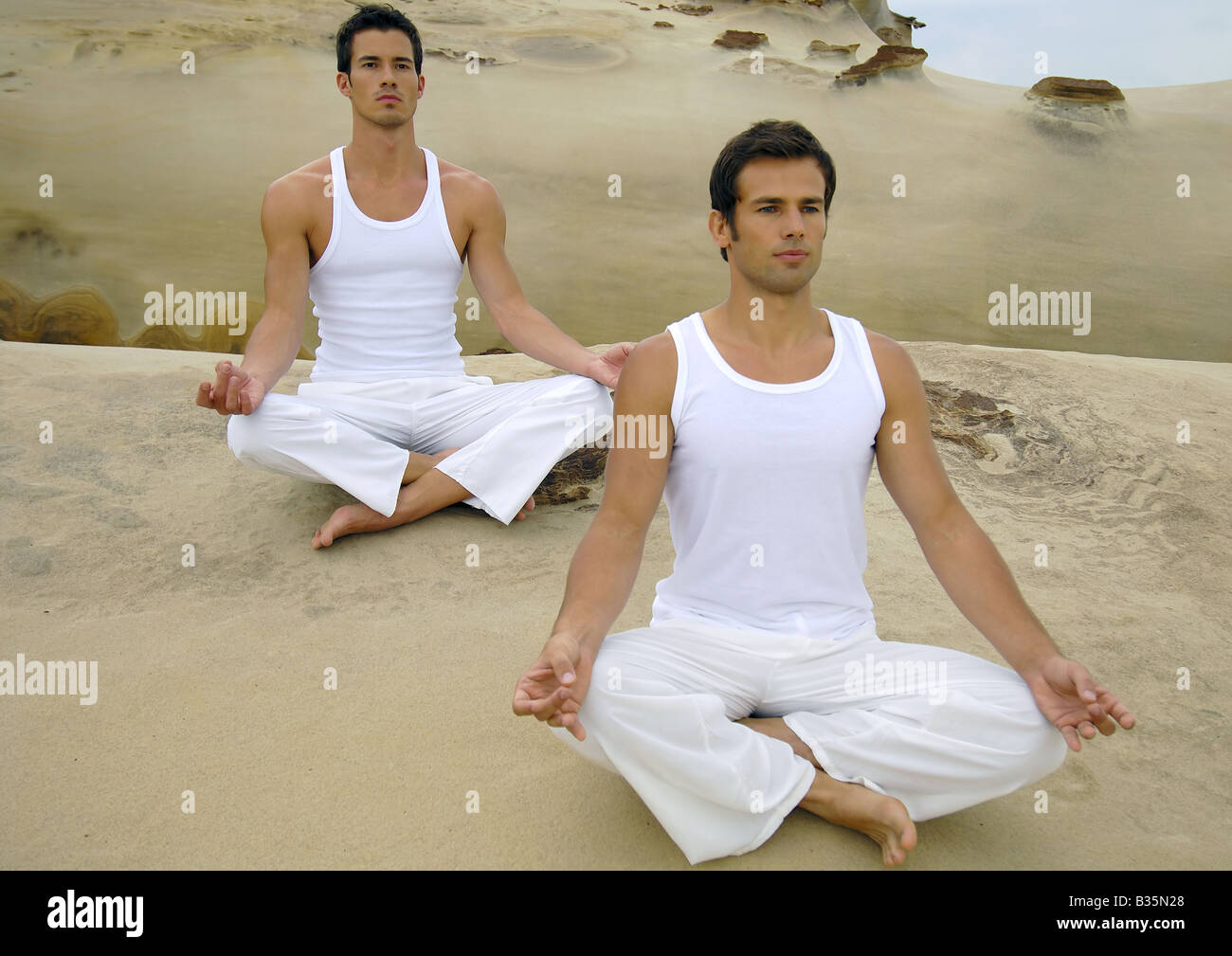 Two young men practicing yoga Stock Photo - Alamy